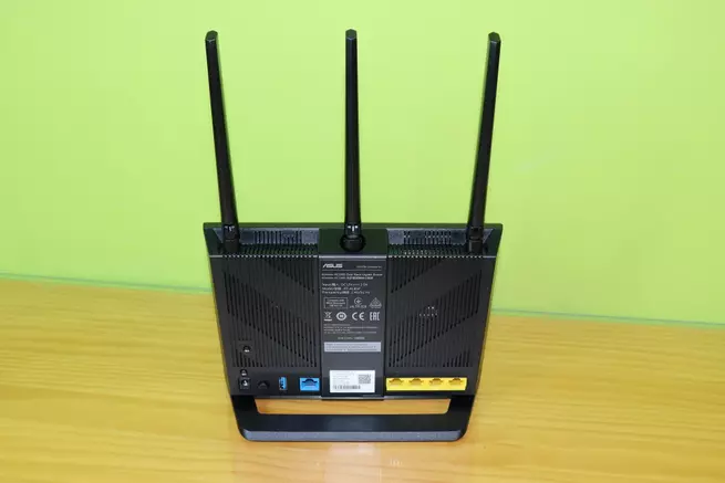 Sa likuran ng ASUS RT-AC85P router na may mga wired na koneksyon at mga pindutan